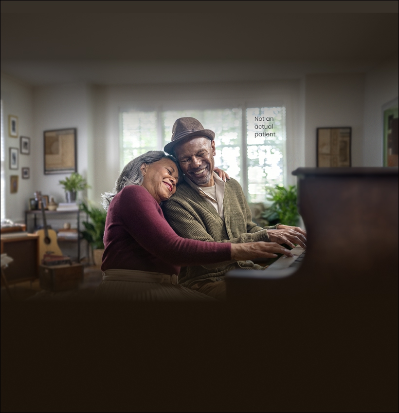 Elderly couple sitting closely together in front of piano